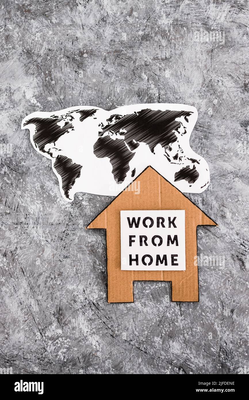 work from home sign with world map and house made of cardboard on grey ...