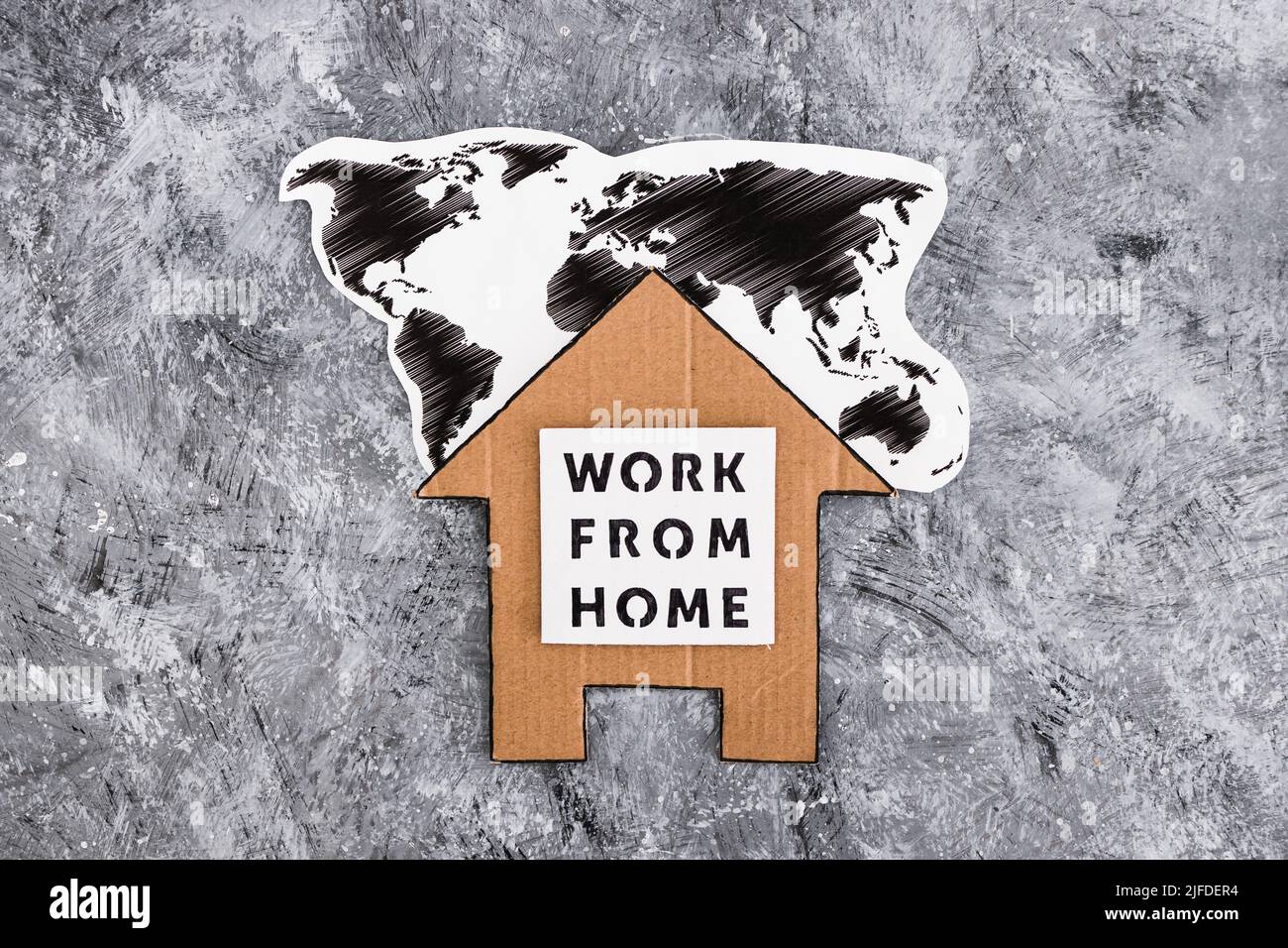 work from home sign with world map and house made of cardboard on grey ...
