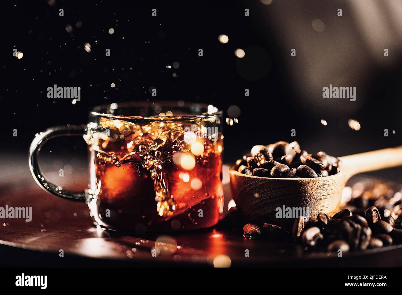 Adding ice cubes to black coffee, the traditional artisanal coffee ...