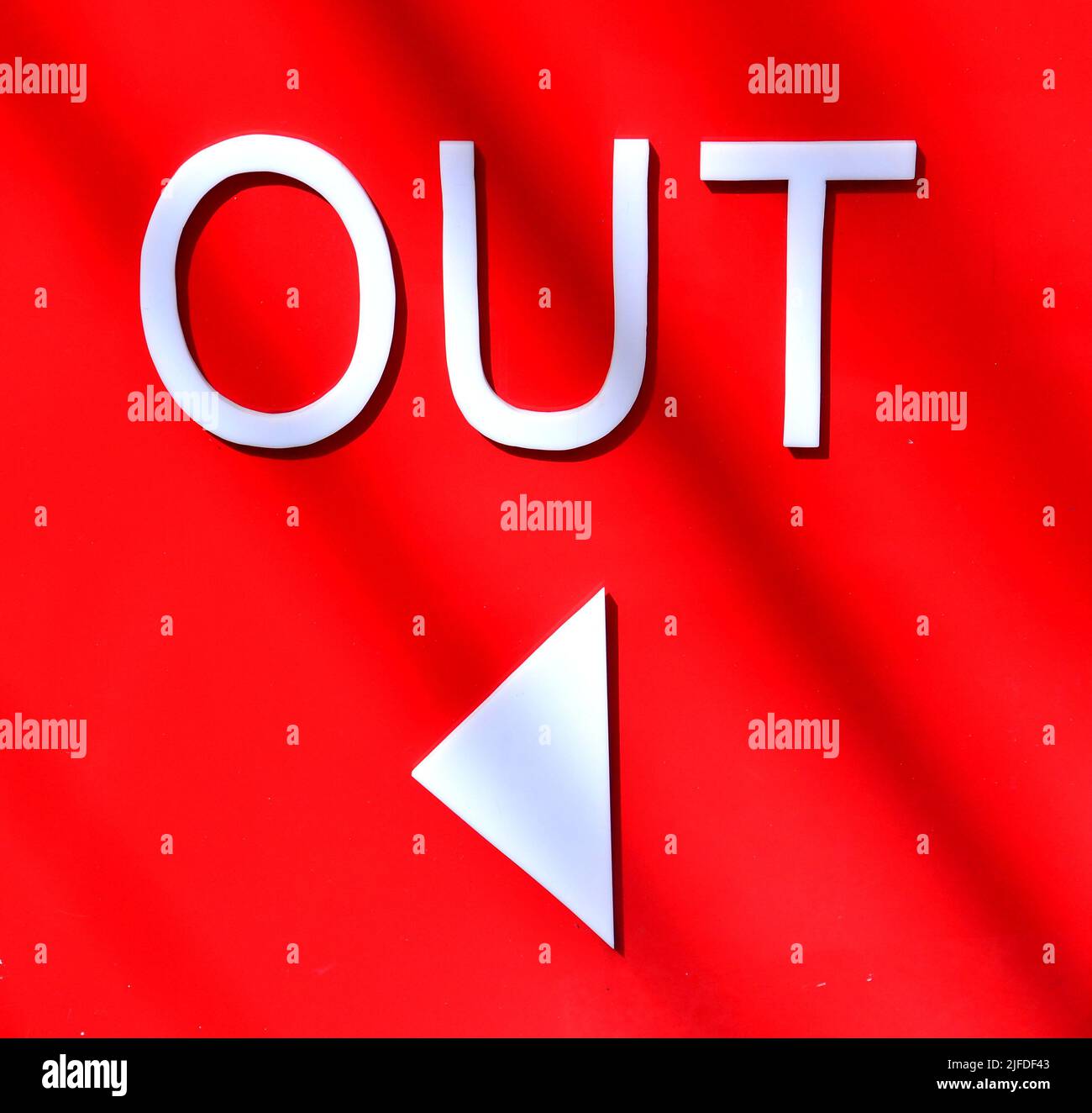 OUT sign with white letters and a white arrow on a red plastic ...