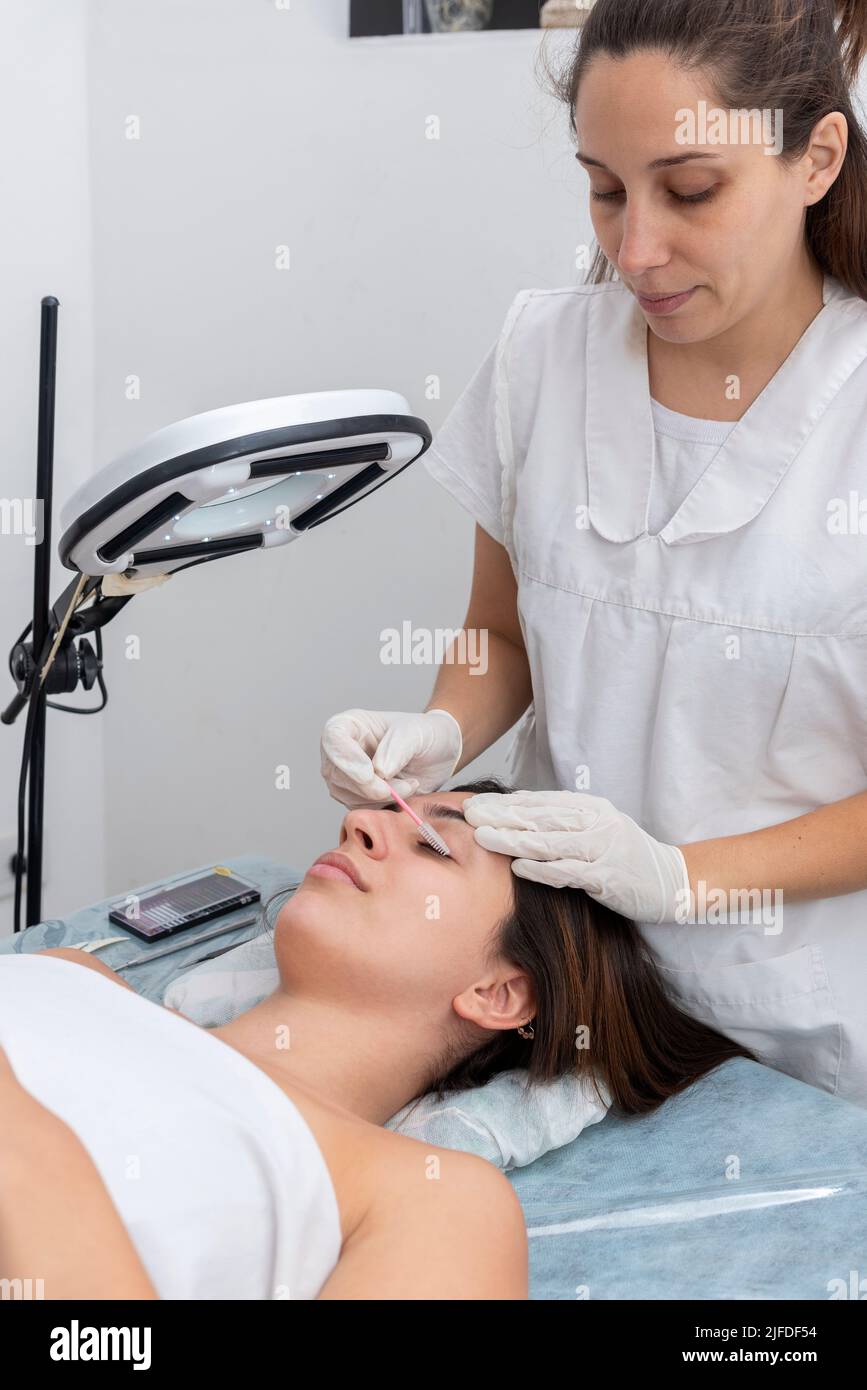 A vertical shot of a young female in aesthetic center performing beauty ...