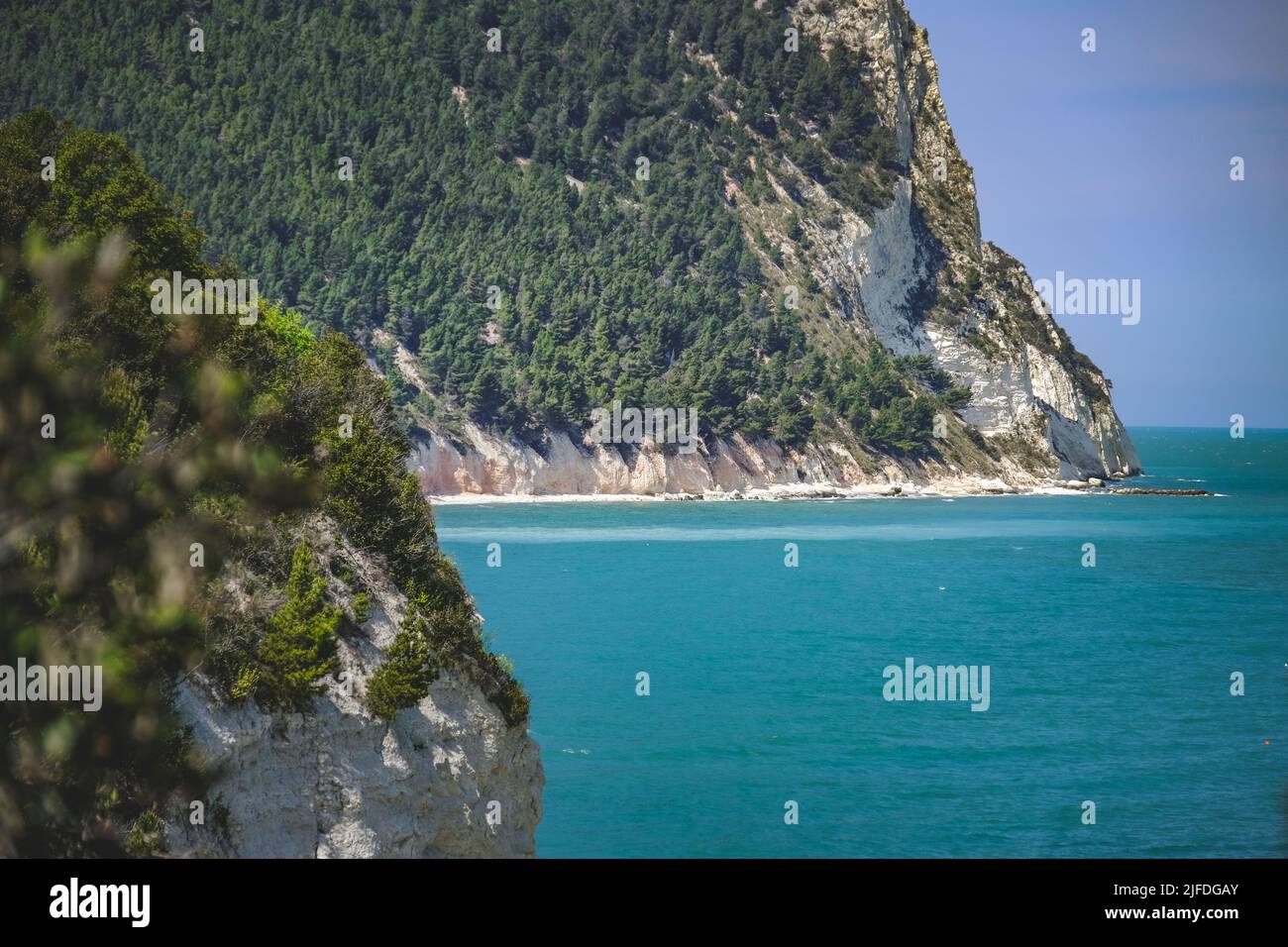 A breathtaking view of large green steep cliff and blue sea water Stock ...