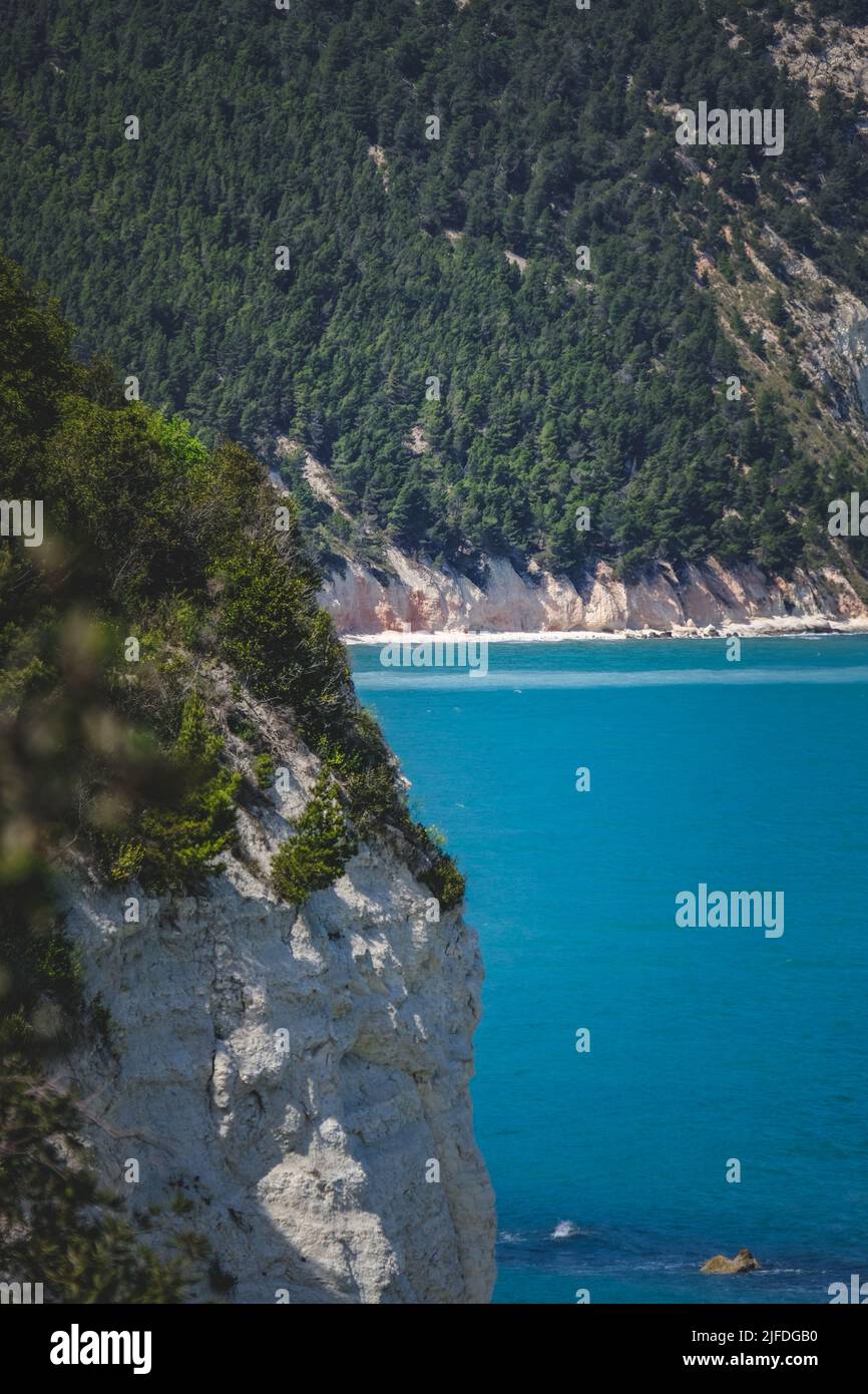 A breathtaking view of large green steep cliff and blue sea water Stock ...