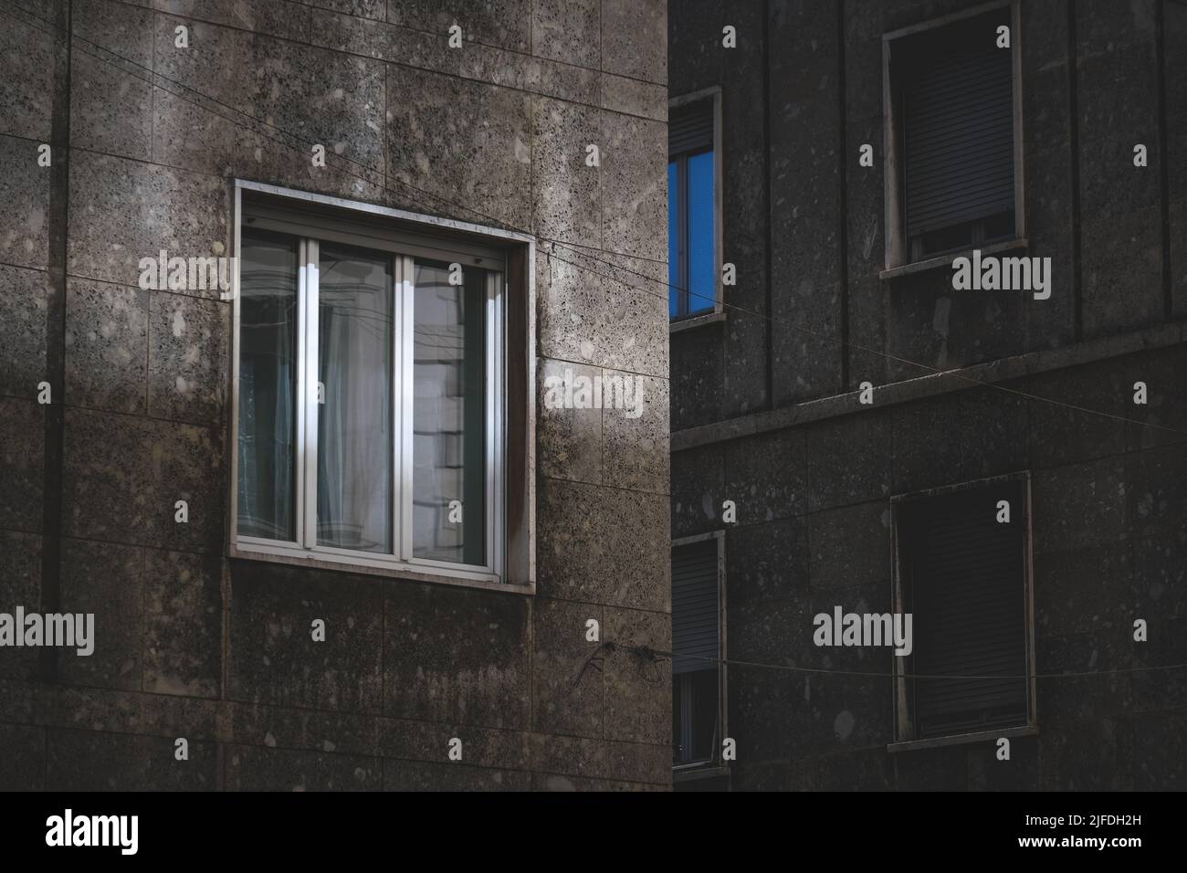 A gray apartment building with white windows Stock Photo - Alamy