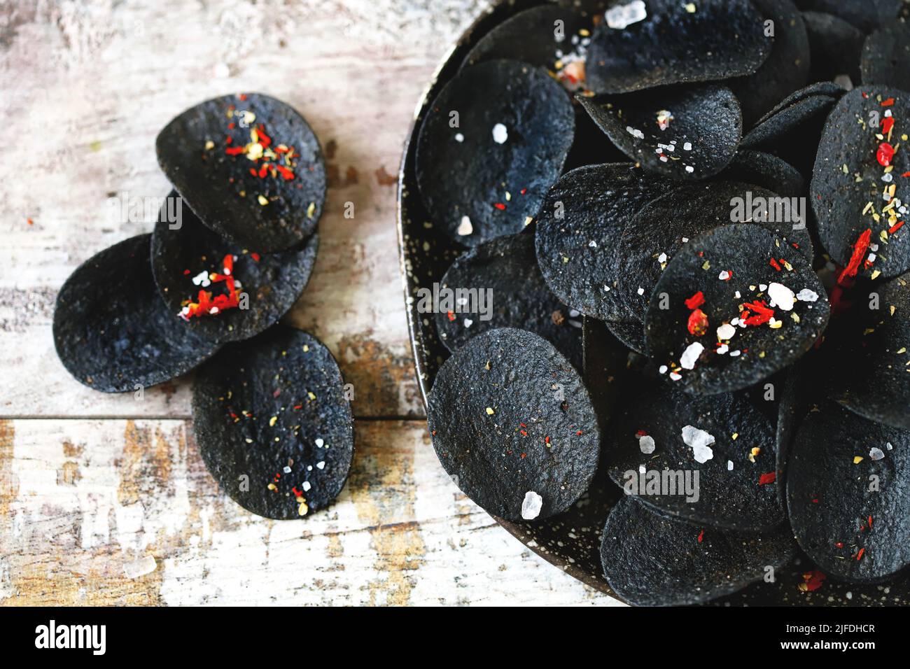Black food. Black chips with spices on a plate. Black food trend ...