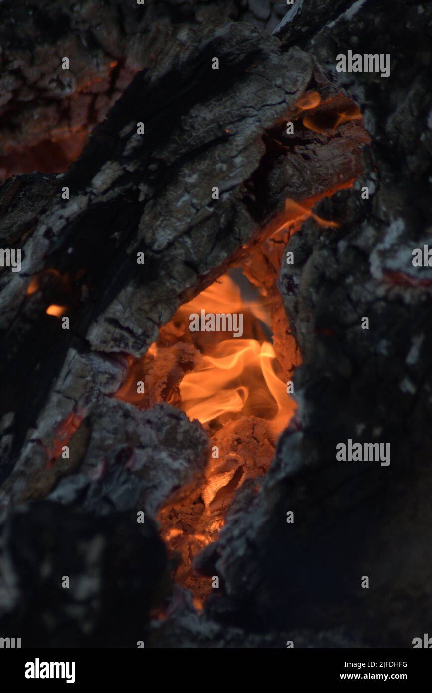 Wooden log burning in a barbecue Stock Photo - Alamy