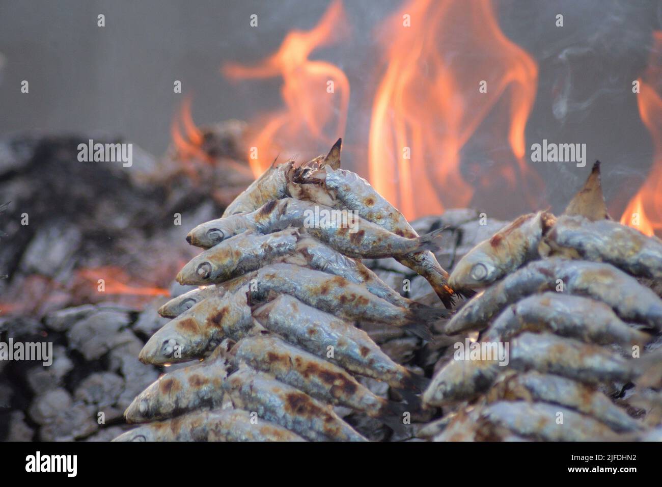 Sardines espetos grilled at fire, typical spanish food Stock Photo - Alamy