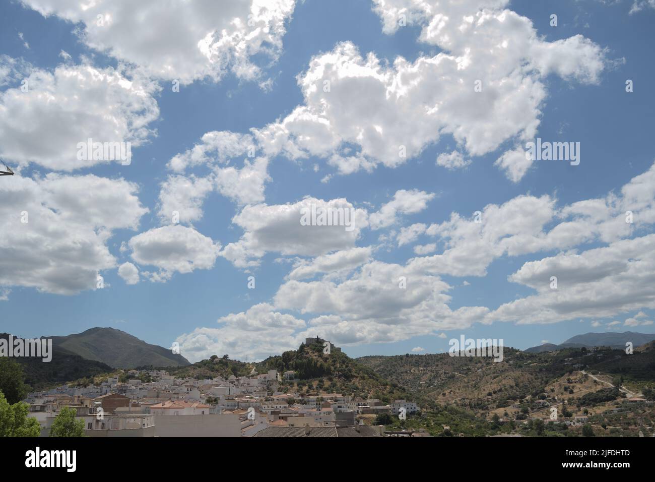 Andalusian village of Monda with clouds in the blue sky, Malaga, Spain ...