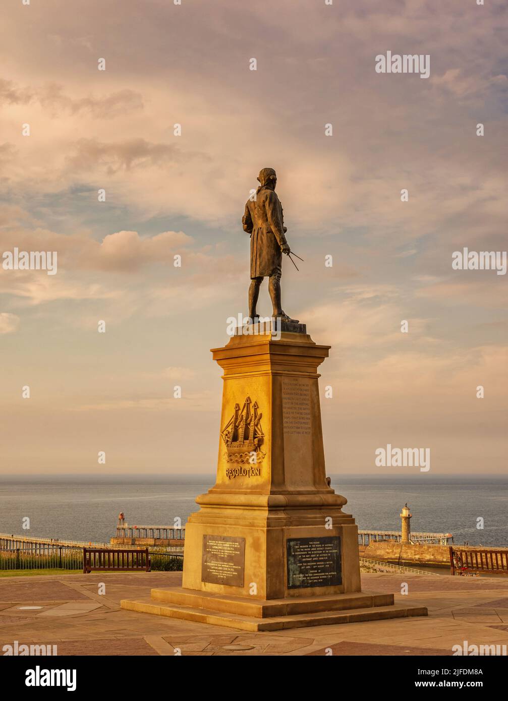 A statue of Captain Cook looks out over the sea and a lighthouse. An ...