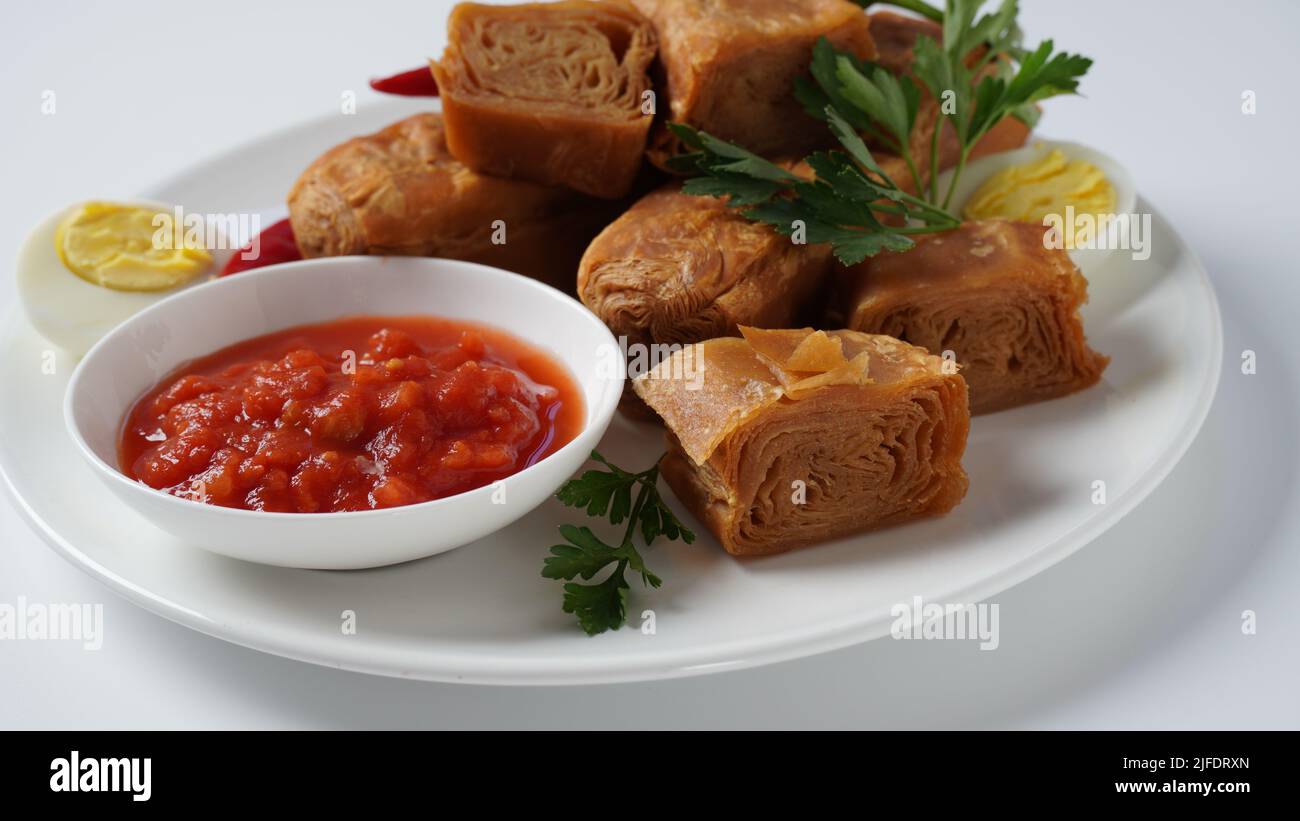 Jachnun or Jahnun, Yemenite Jewish pastry, served with fresh grated ...