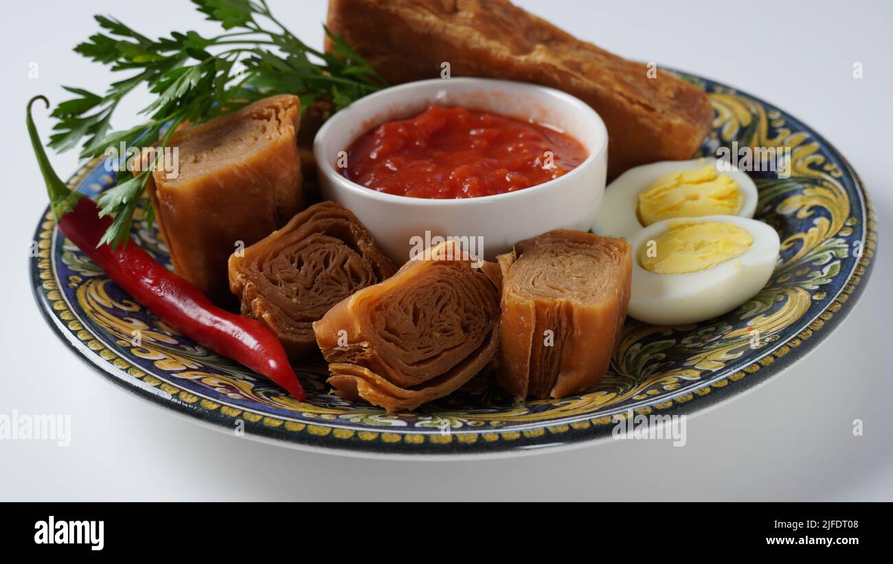 Jachnun or Jahnun, Yemenite Jewish pastry, served with fresh grated ...