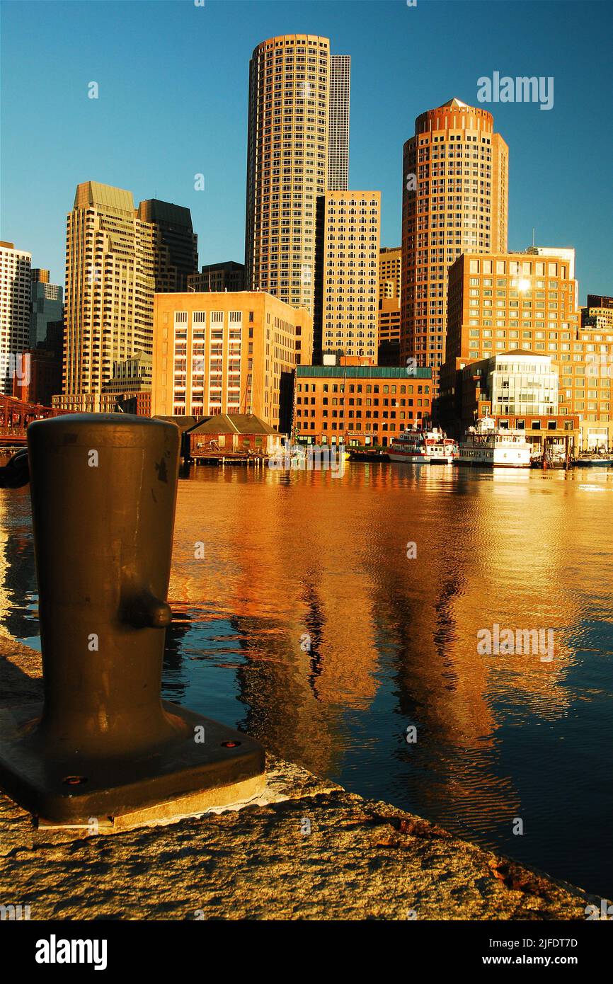The skyscrapers of Rowes Wharf in Boston are reflected in the water of ...