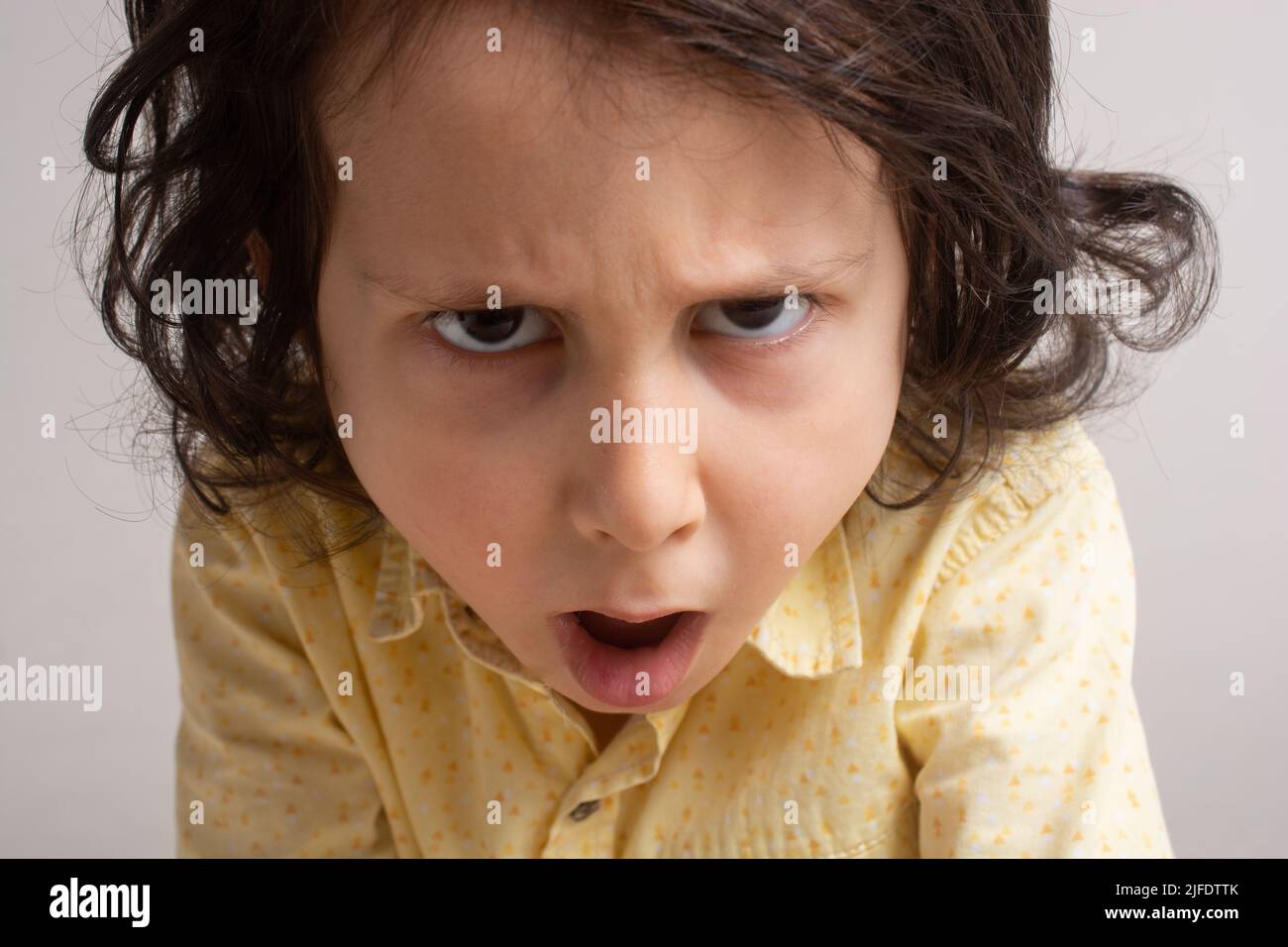 Little cute boy trying to make a serious face Stock Photo - Alamy