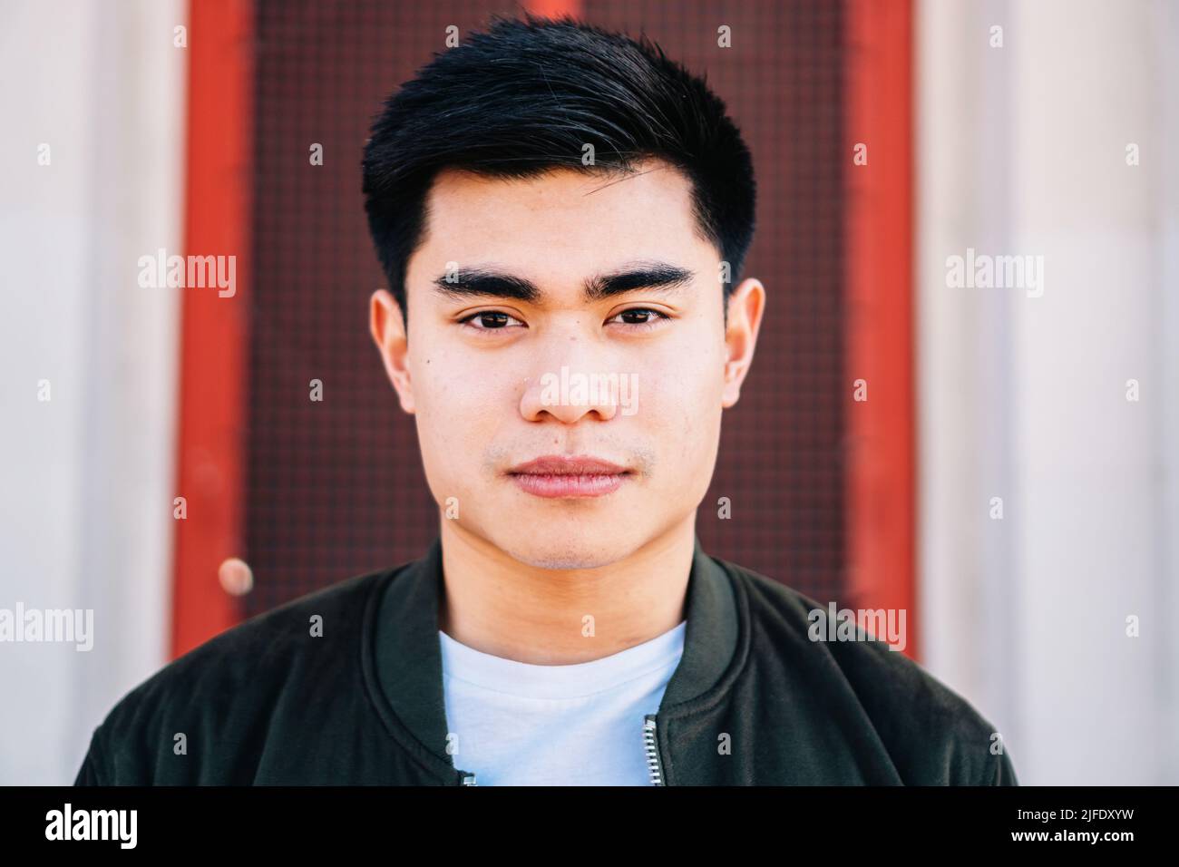 Portrait of serious asian guy looking at camera outdoors Stock Photo ...