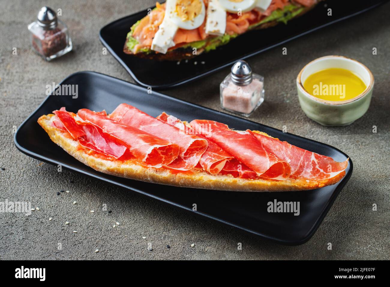 Traditional Spanish breakfast. Tostada with different toppings on a ...