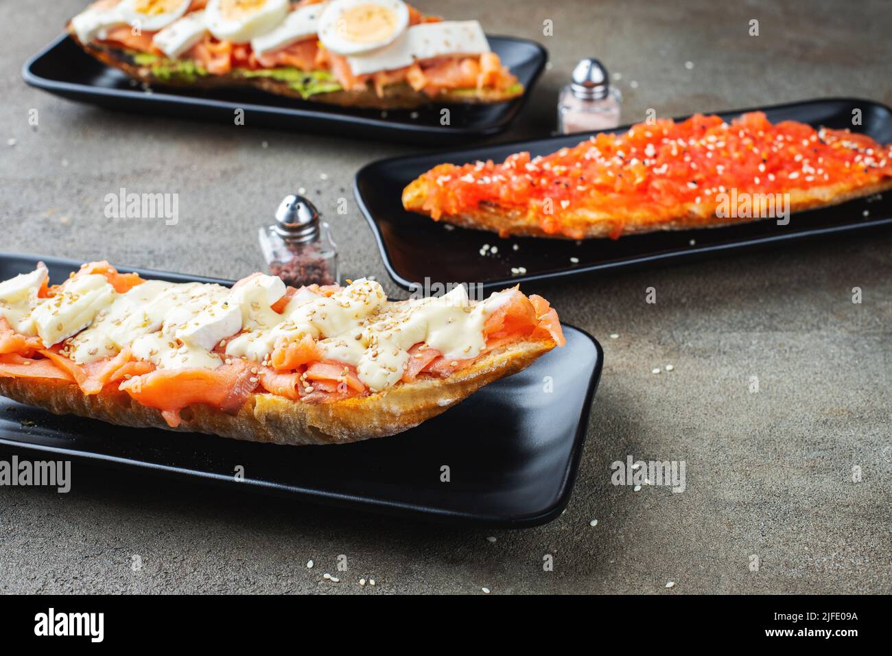 Traditional Spanish breakfast. Tostada with different toppings on a ...