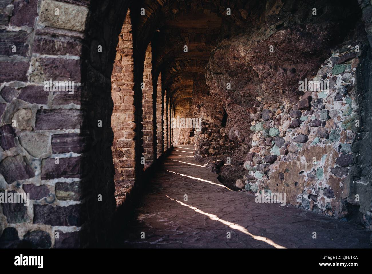 The interior of an old castle tunnel with stone walls and arches Stock ...
