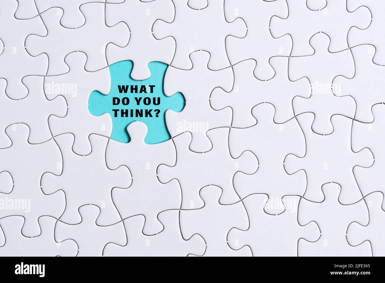 White jigsaw puzzle with text over blue background - What do you think ...