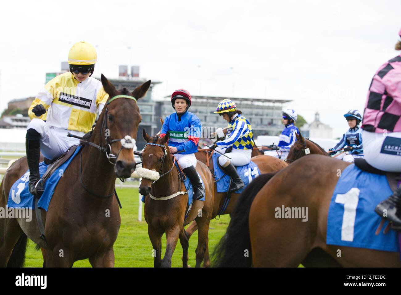 A group of Female Amateur Jockeys line up before the starting gates at ...