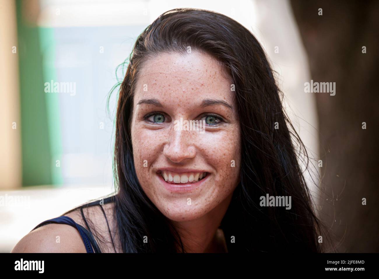 portrait of young female student with freckles and blue eyes looking ...