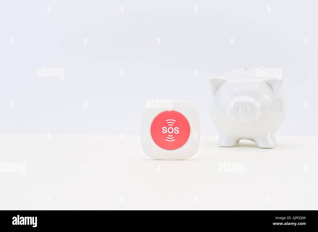 red SOS help button with piggy bank on a white desk - inflation and ...
