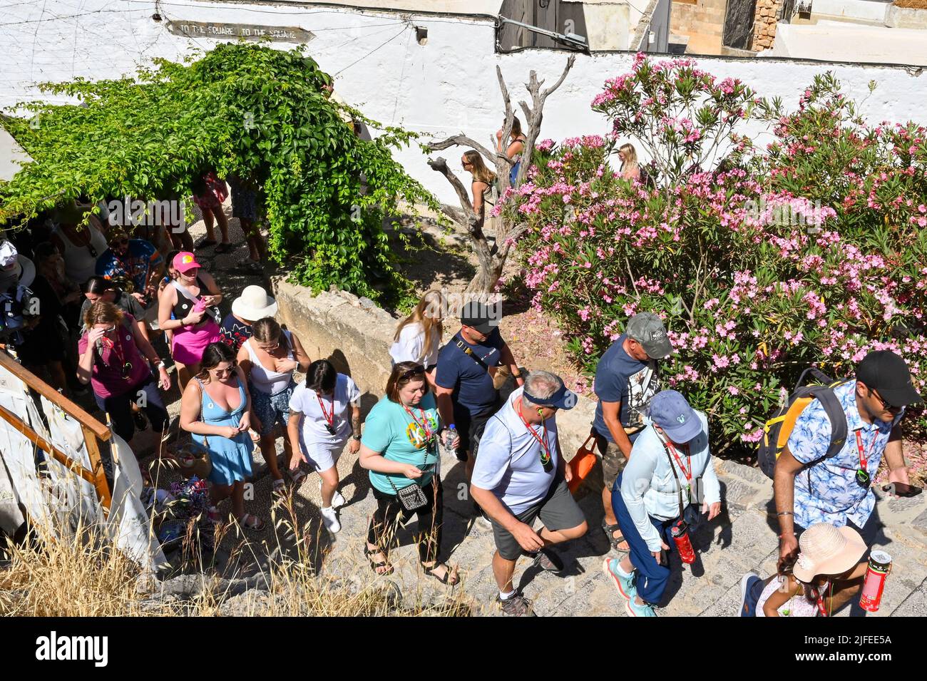 Lindos, Rhodes, Greece - May 2022: Visitors climbing the steps to reach ...