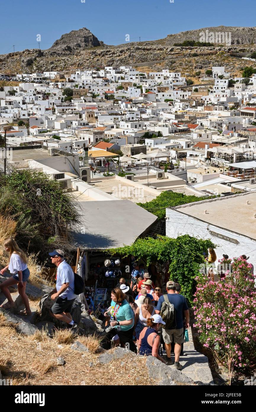 Lindos, Rhodes, Greece - May 2022: Visitors climbing the steps to reach ...