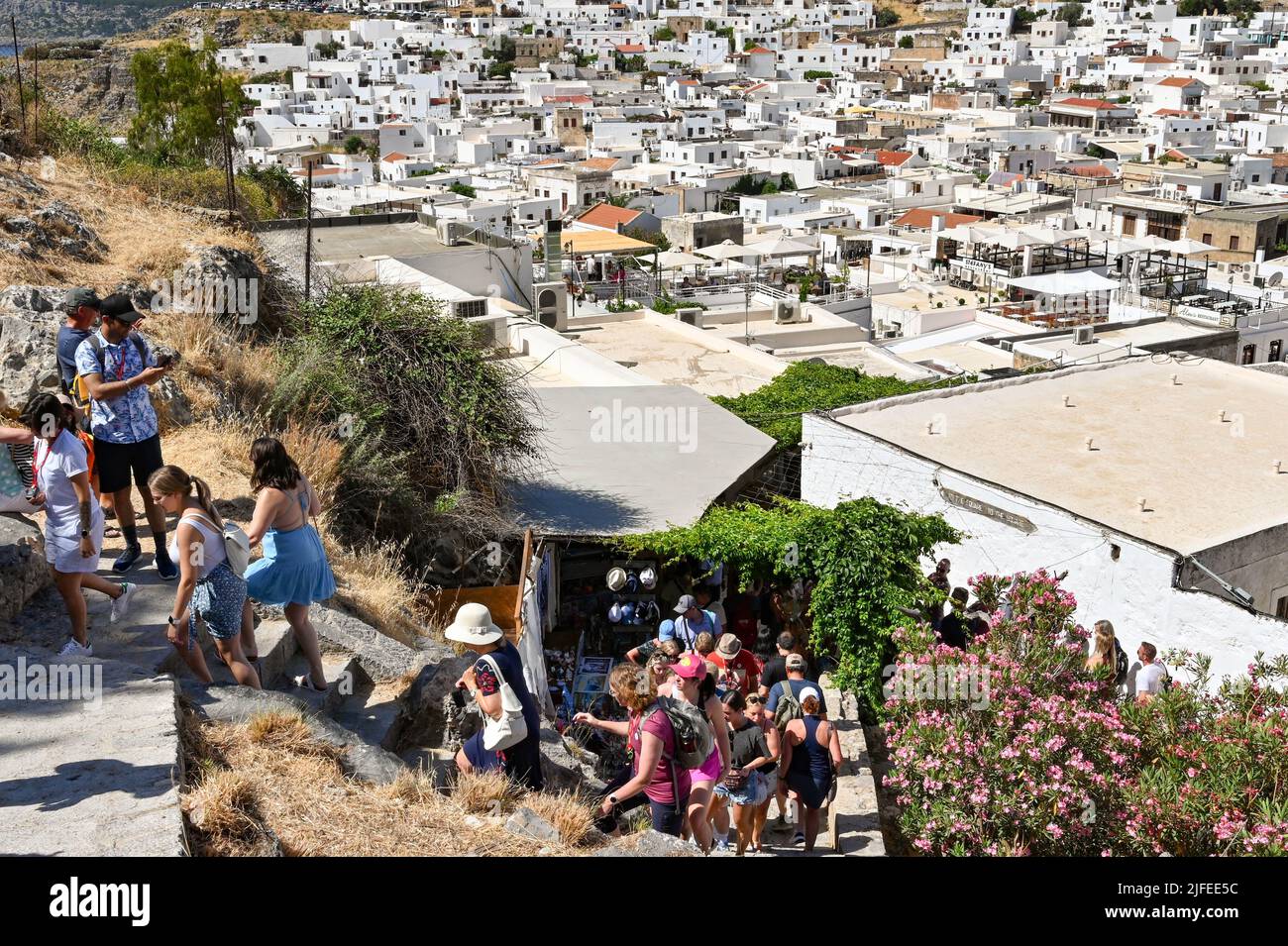 Lindos, Rhodes, Greece - May 2022: Visitors climbing the steps to reach ...