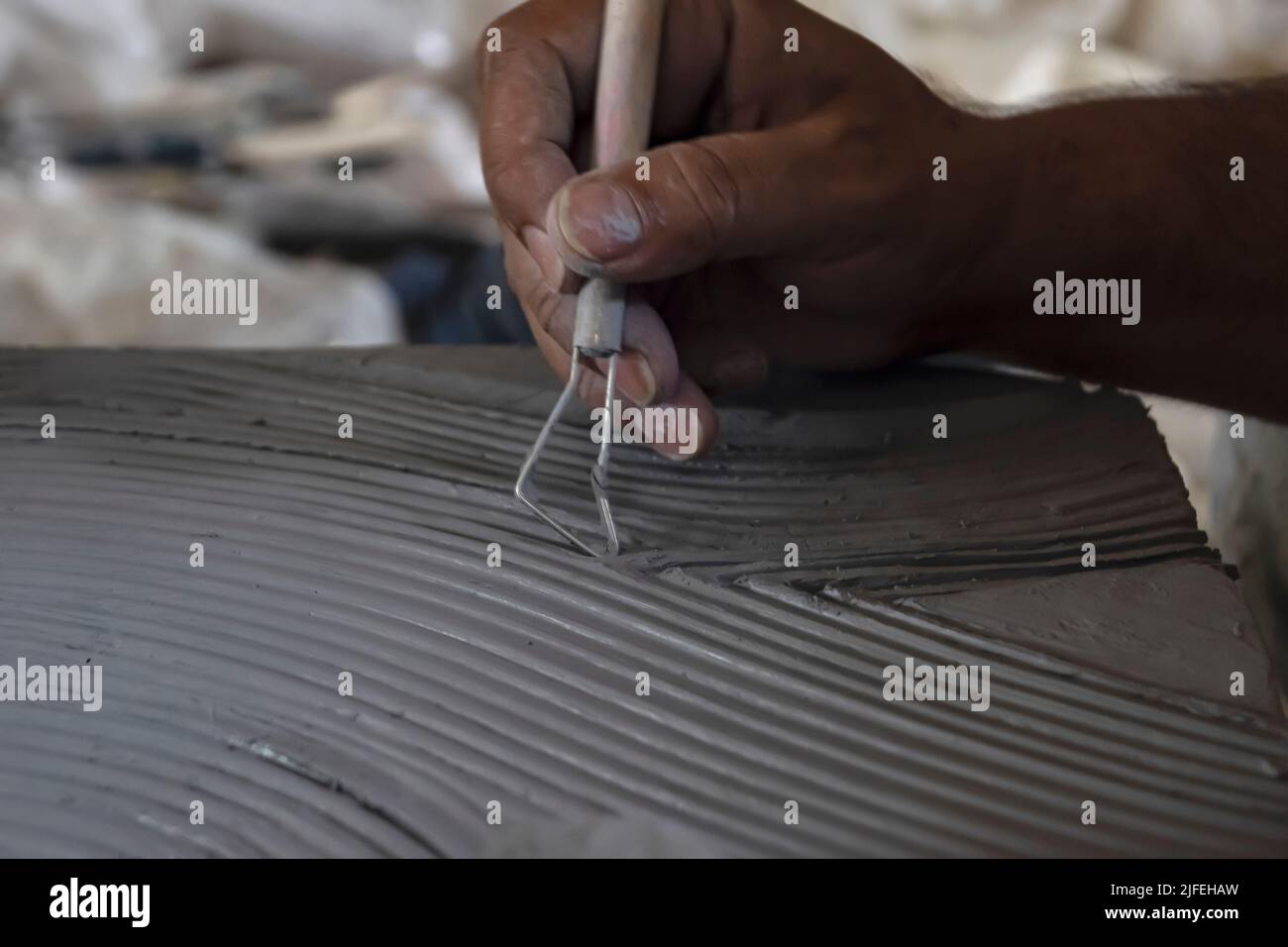 Close up of male sculptor holding tool and making art on clay. Clay ...