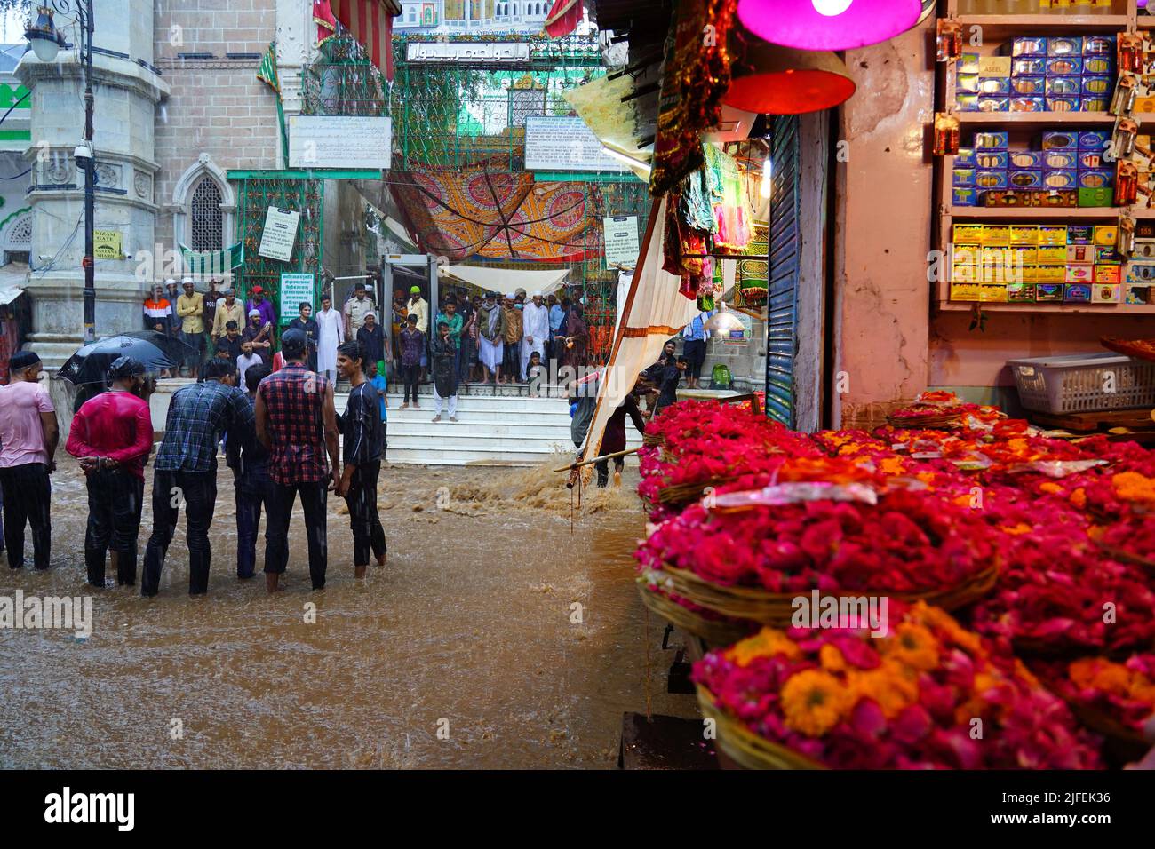 Indian People wade through a waterlogged street after a heavy monsoon ...