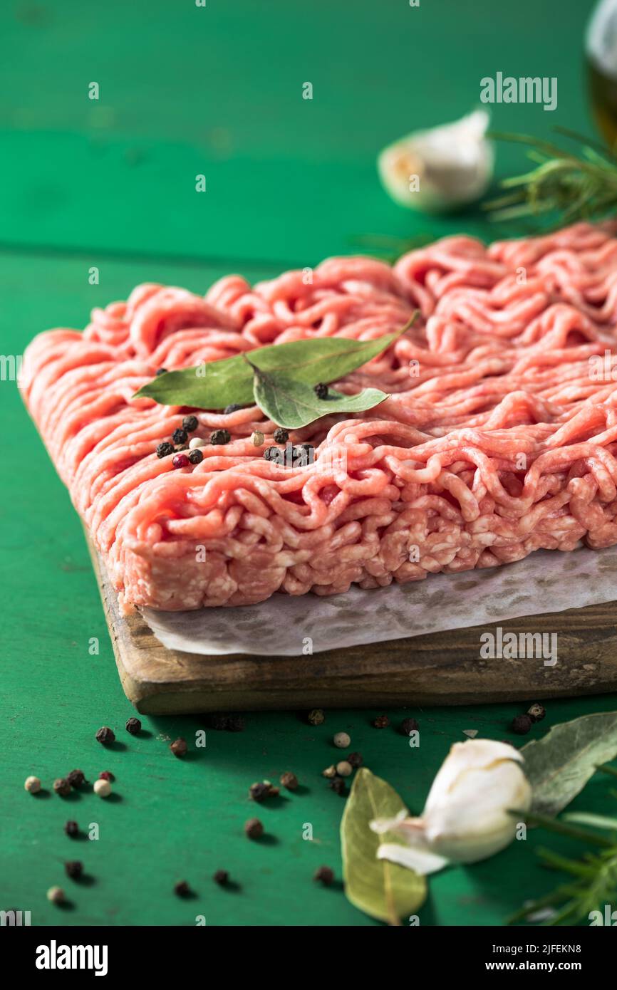 Raw Mince, minced Ground beef meat on a cutting board. Green background ...