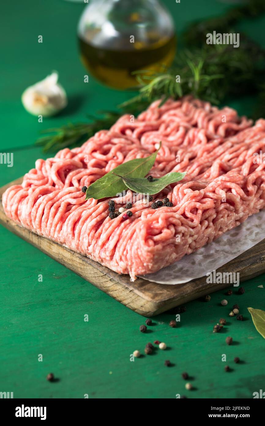 Raw Mince, minced Ground beef meat on a cutting board. Green background ...