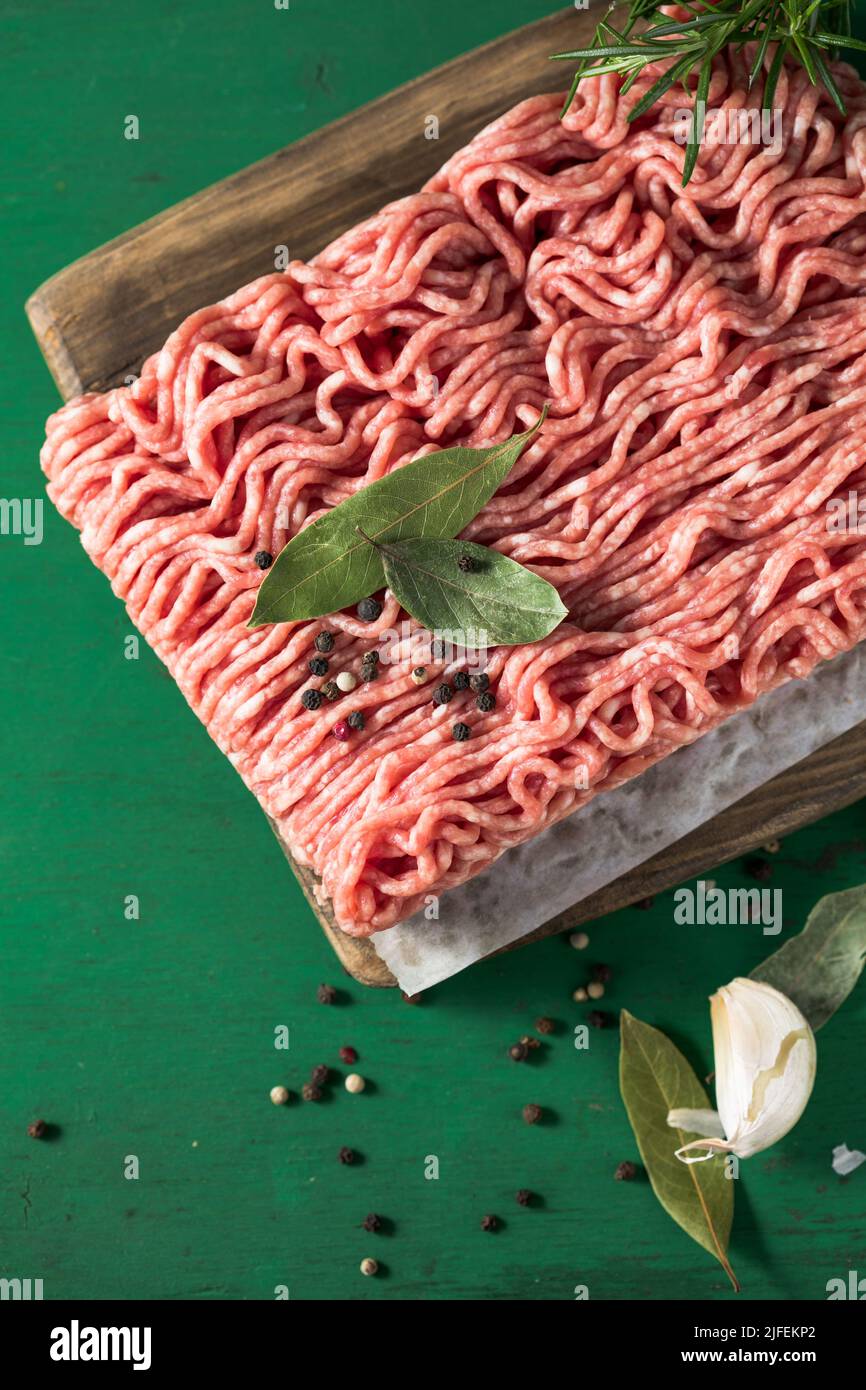 Raw Mince, minced Ground beef meat on a cutting board. Green background ...