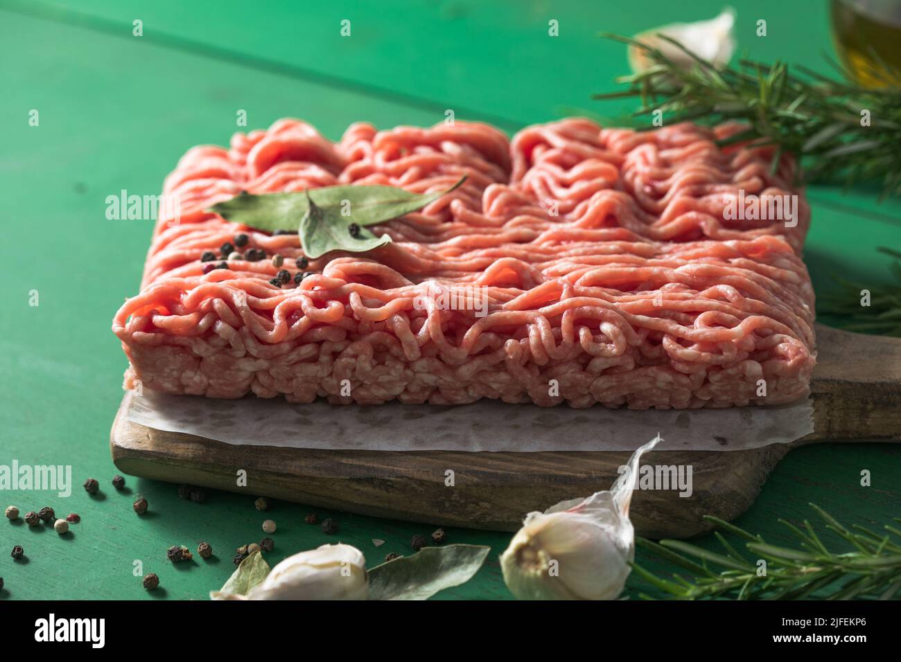 Raw Mince, minced Ground beef meat on a cutting board. Green background ...