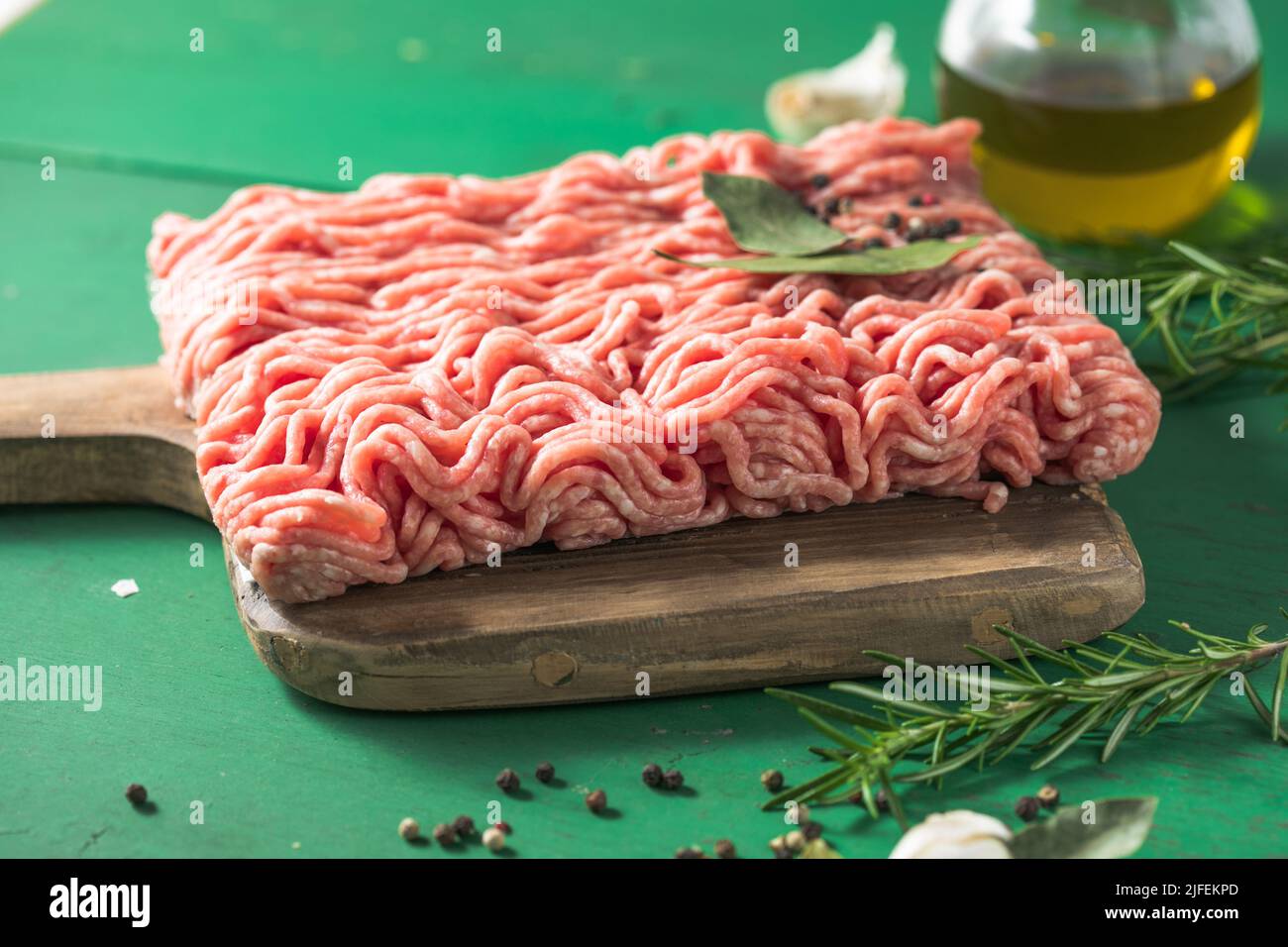 Raw Mince, minced Ground beef meat on a cutting board. Green background ...
