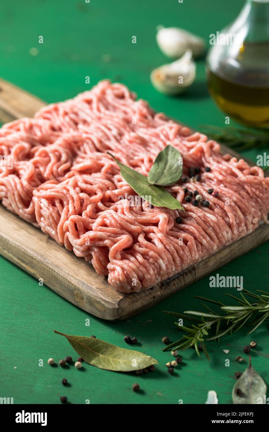 Raw Mince, minced Ground beef meat on a cutting board. Green background ...