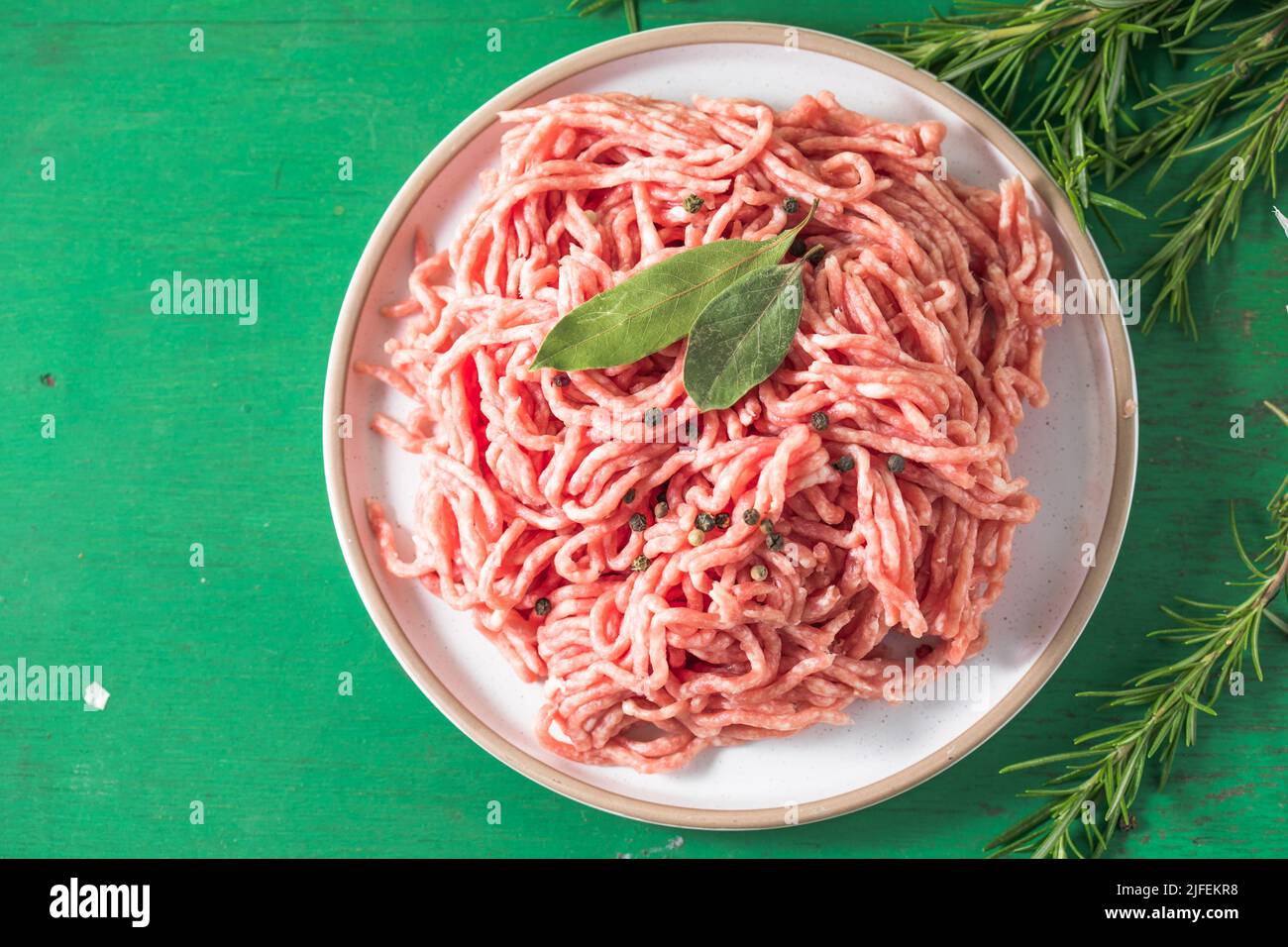 Raw Mince, minced Ground beef meat on a cutting board. Green background ...