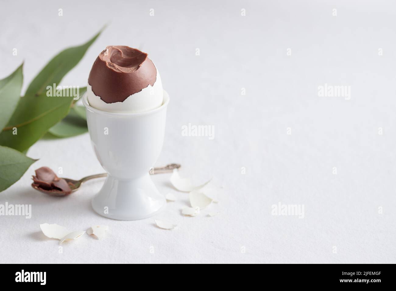 Started chocolate egg on white eggstand holder with copy space Stock ...