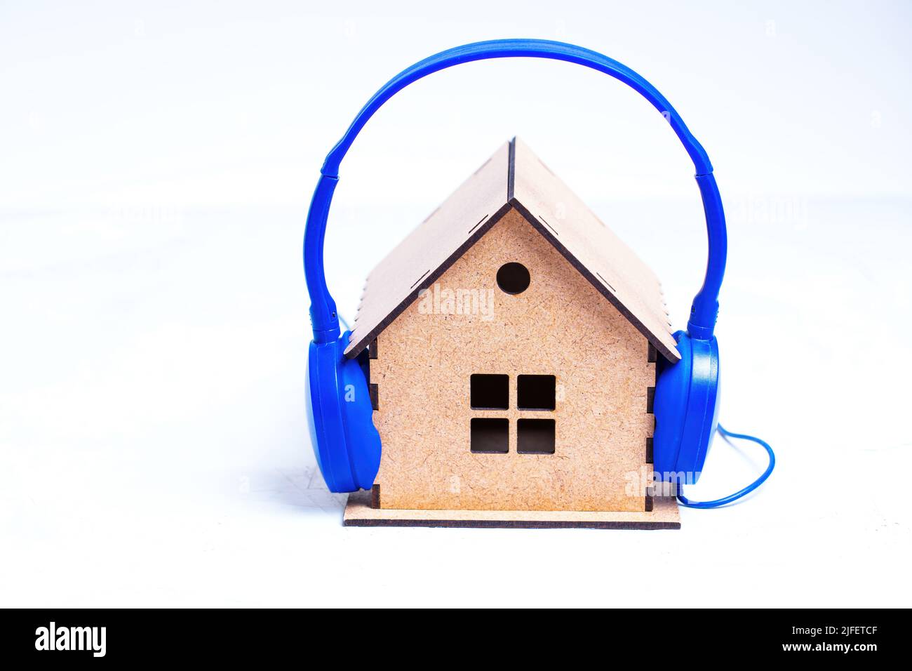 Headphones on a wooden house model isolated on white background ...