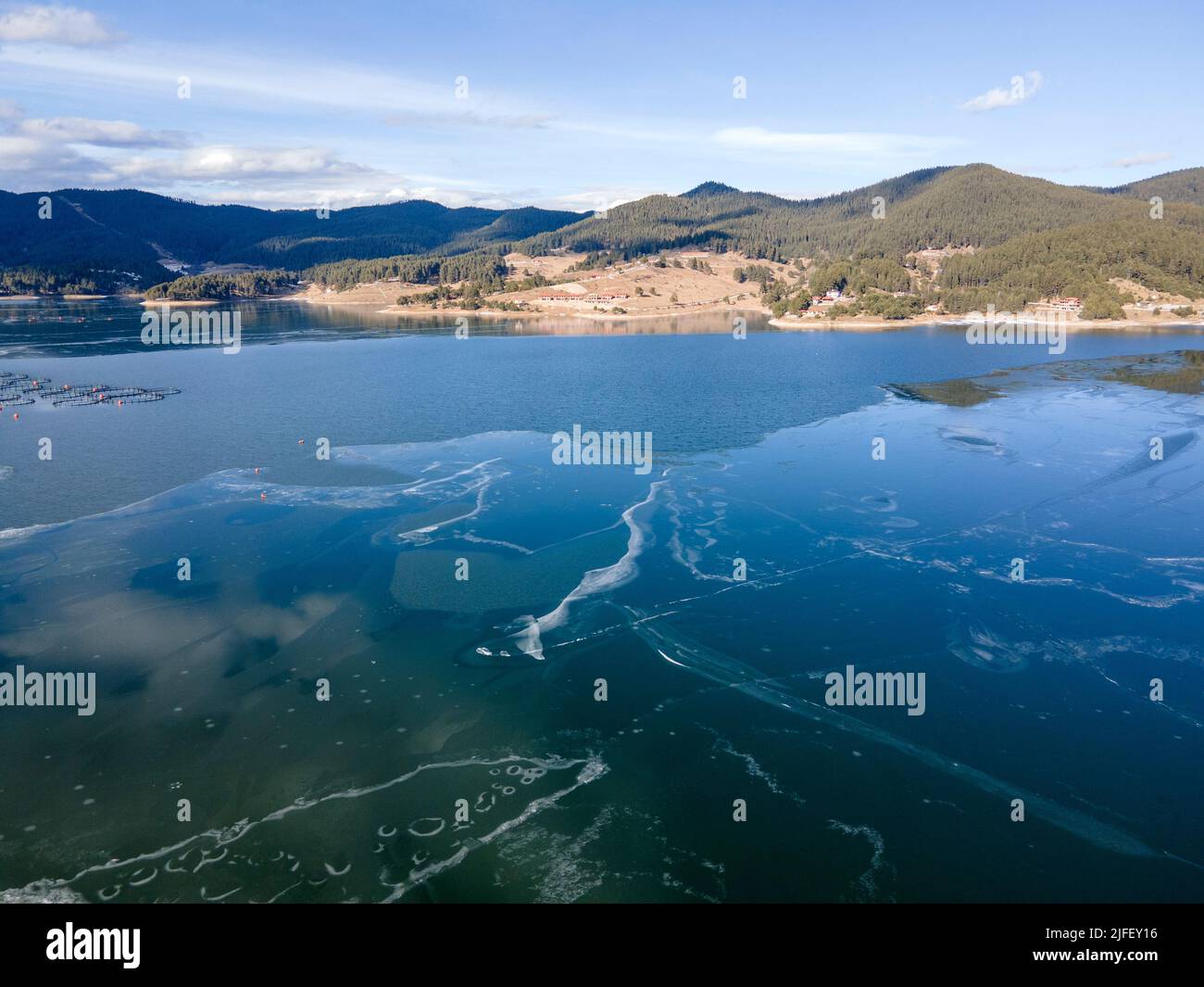 Aerial winter view of Dospat Reservoir covered with ice, Smolyan Region ...