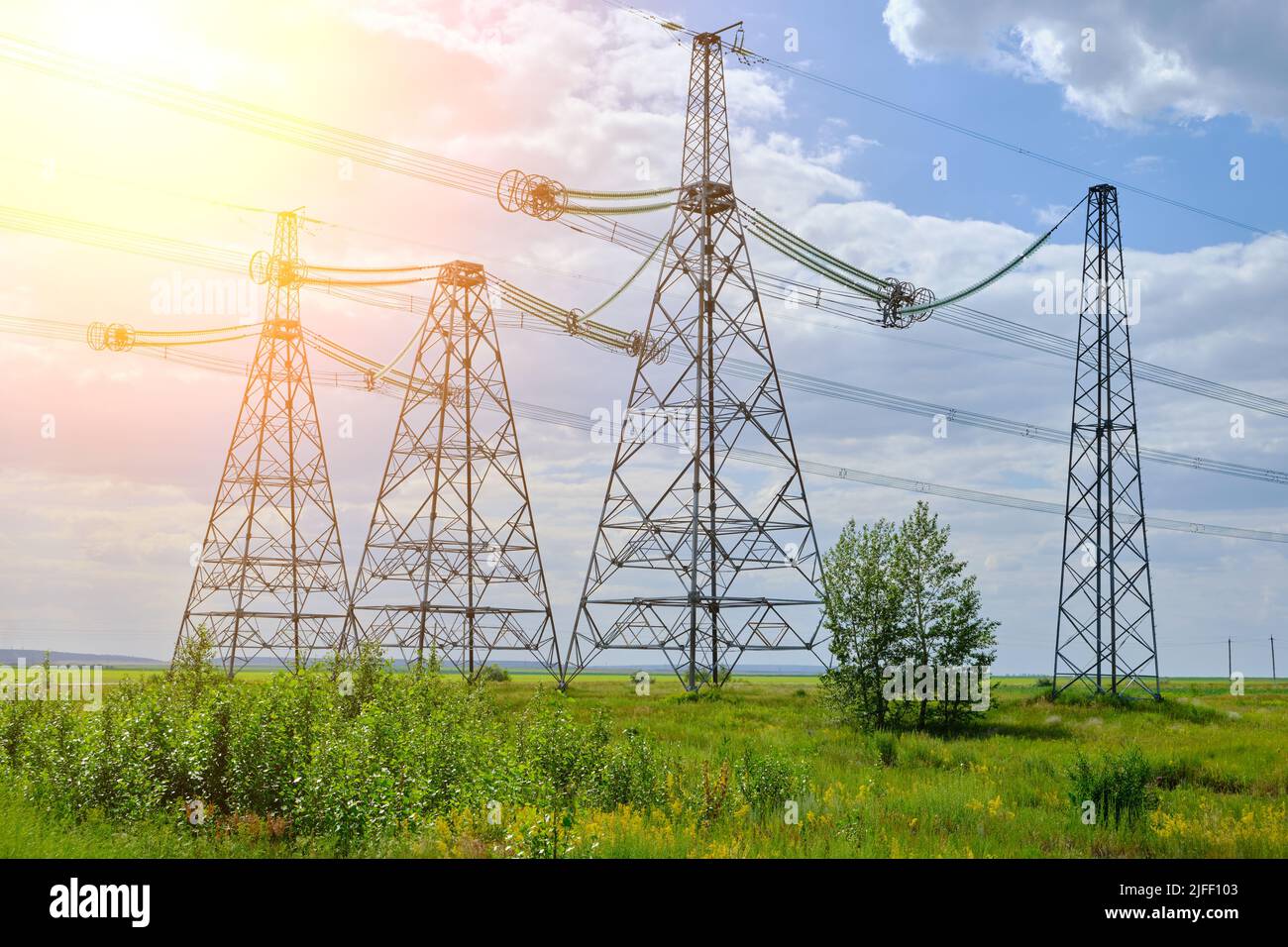 Power line background green meadows and blue sky with bright sun Stock ...