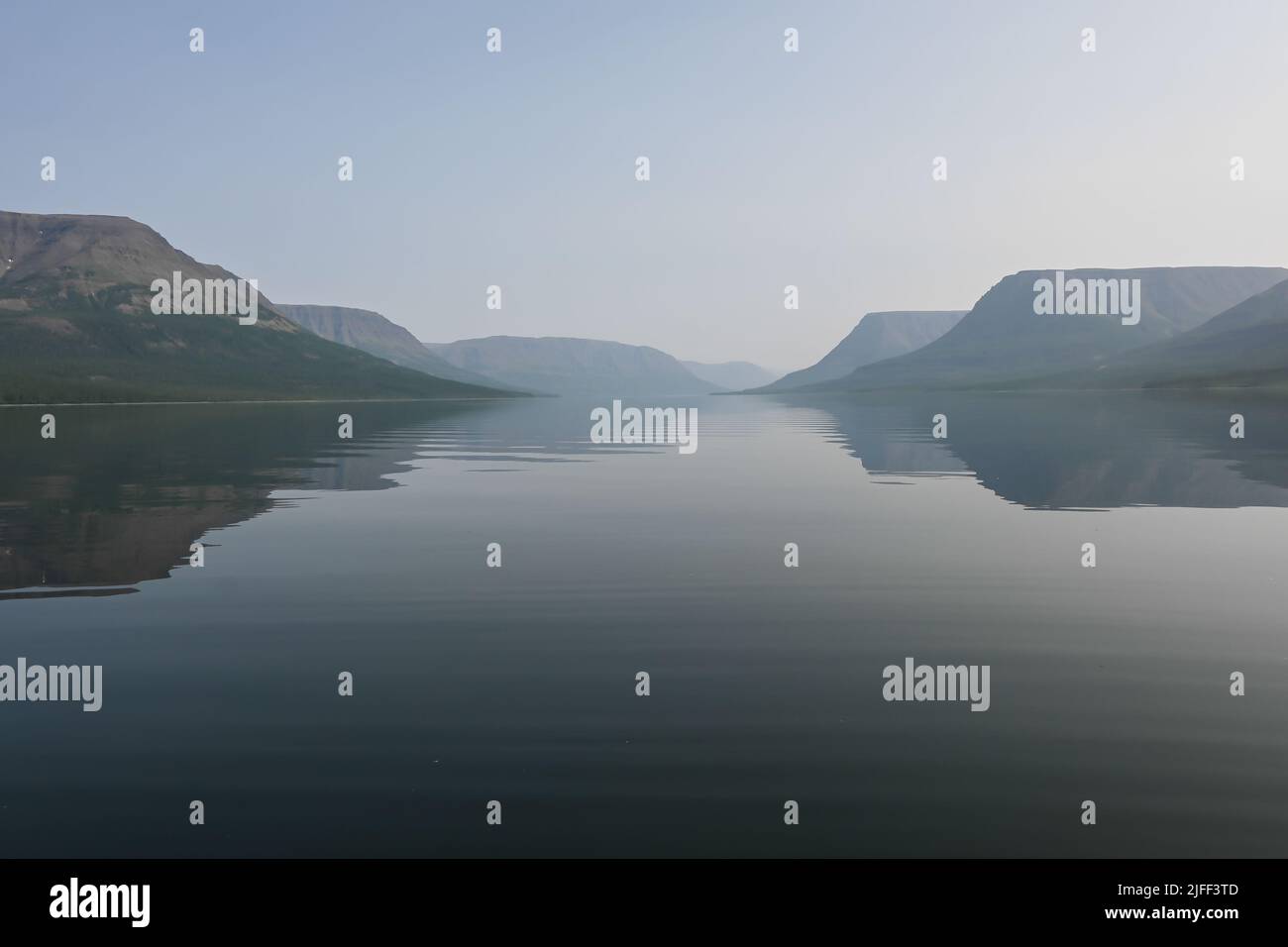A mountain lake in a misty haze. Water landscape of the Putorana ...