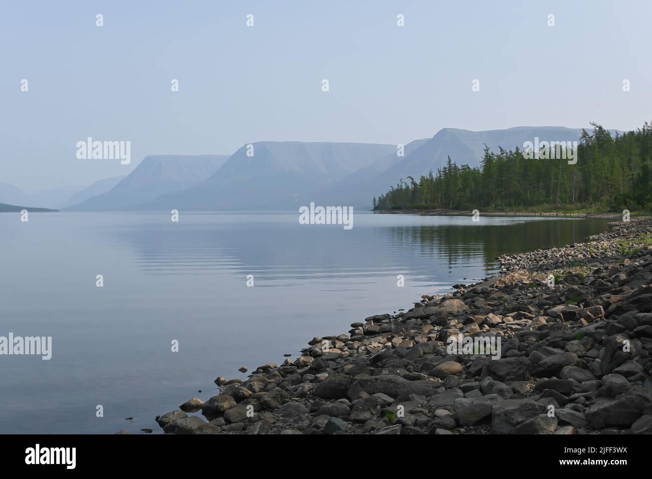 A mountain lake in a misty haze. Water landscape of the Putorana ...