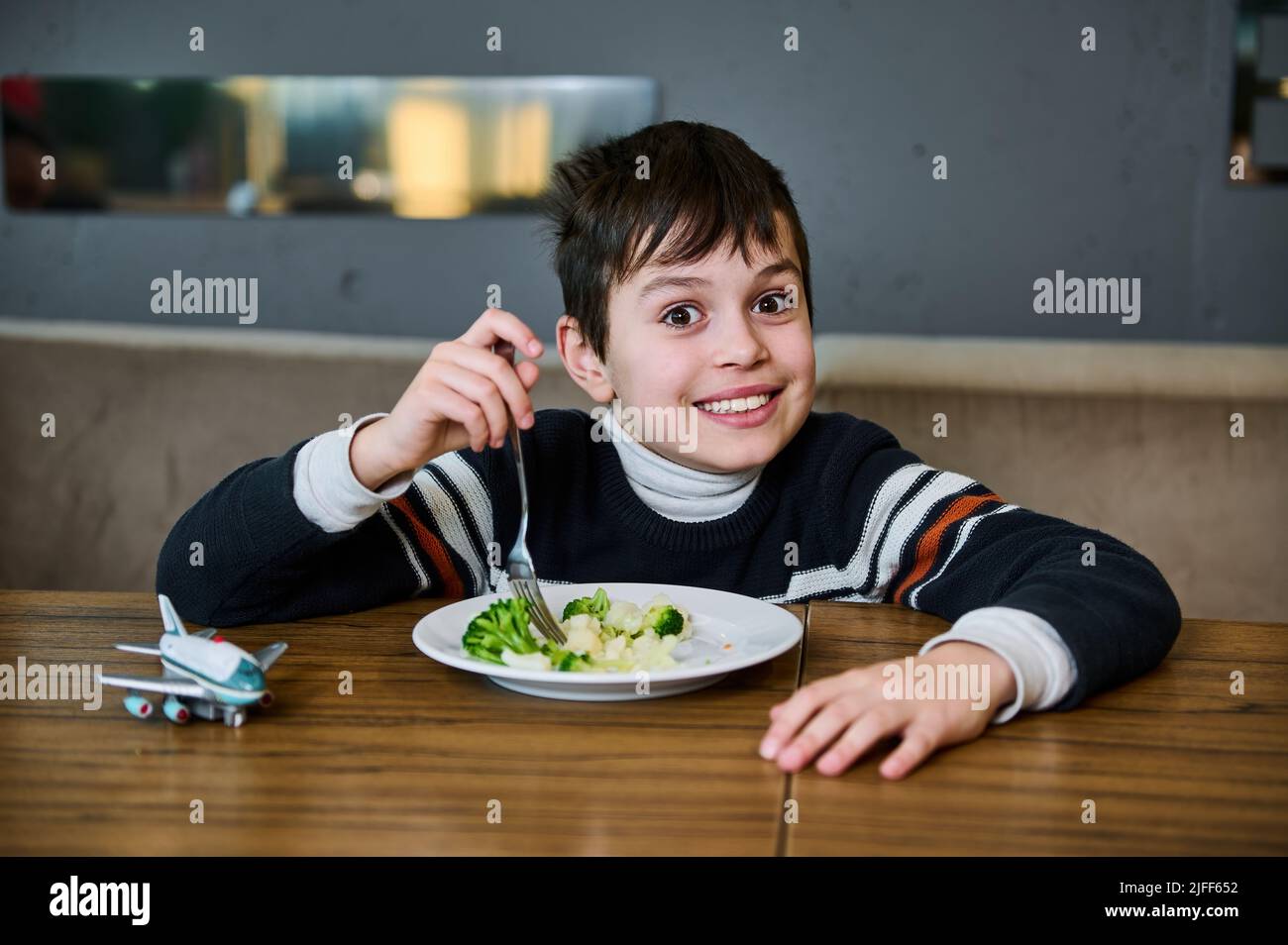 Adorable European boy smiling as he looks at the camera while enjoying ...