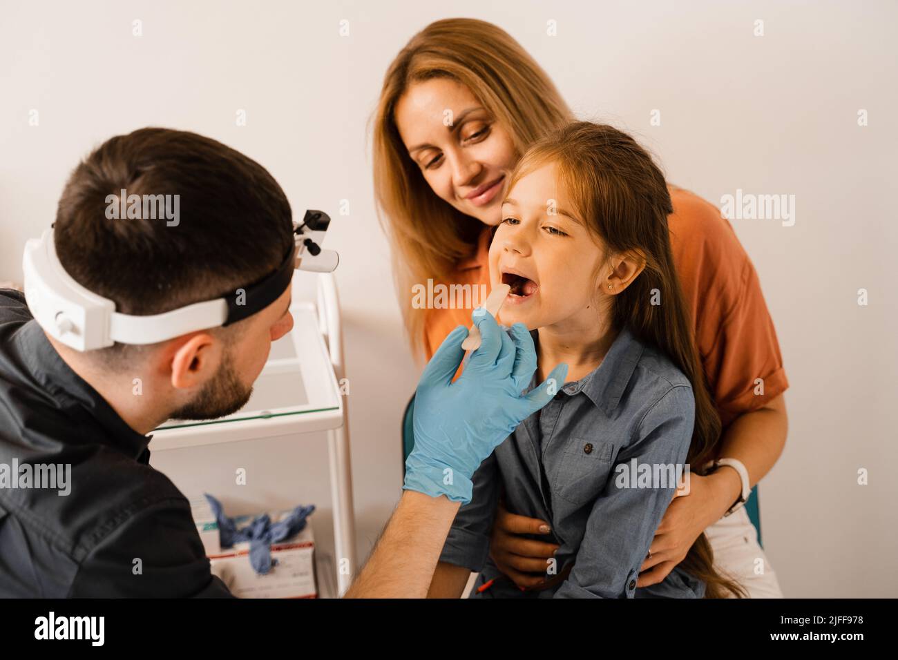 Oropharyngoscopy family procedure for child. Mother with daughter visit ...