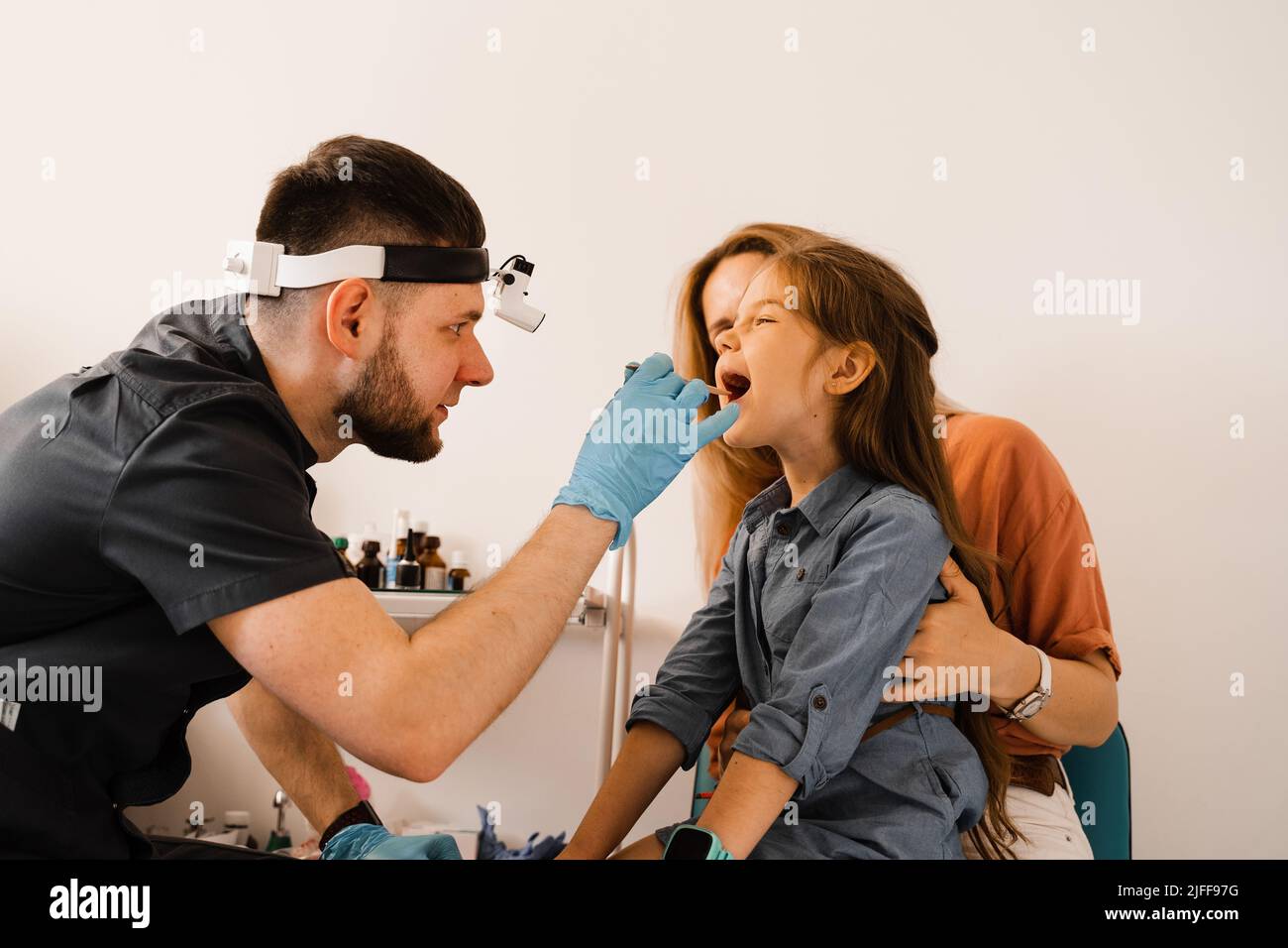 Oropharyngoscopy family procedure for child. Mother with daughter visit ...