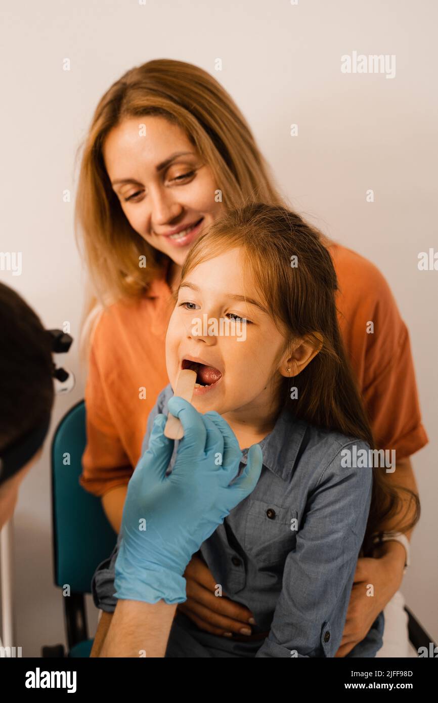 Oropharyngoscopy procedure for child. Otolaryngologist examines child ...