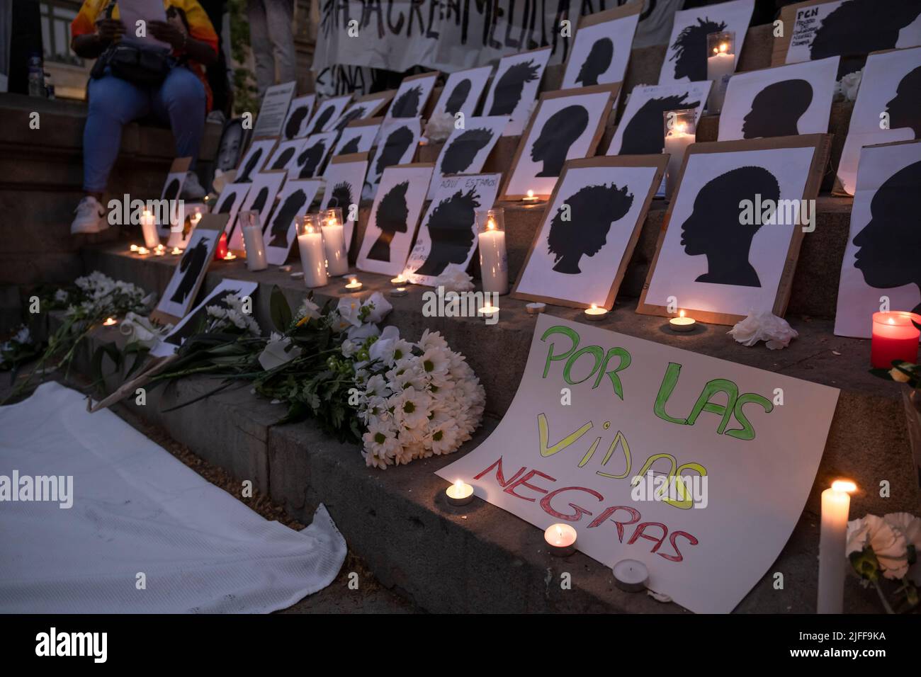 A group of portraits in black are seen placed with candles on the altar ...