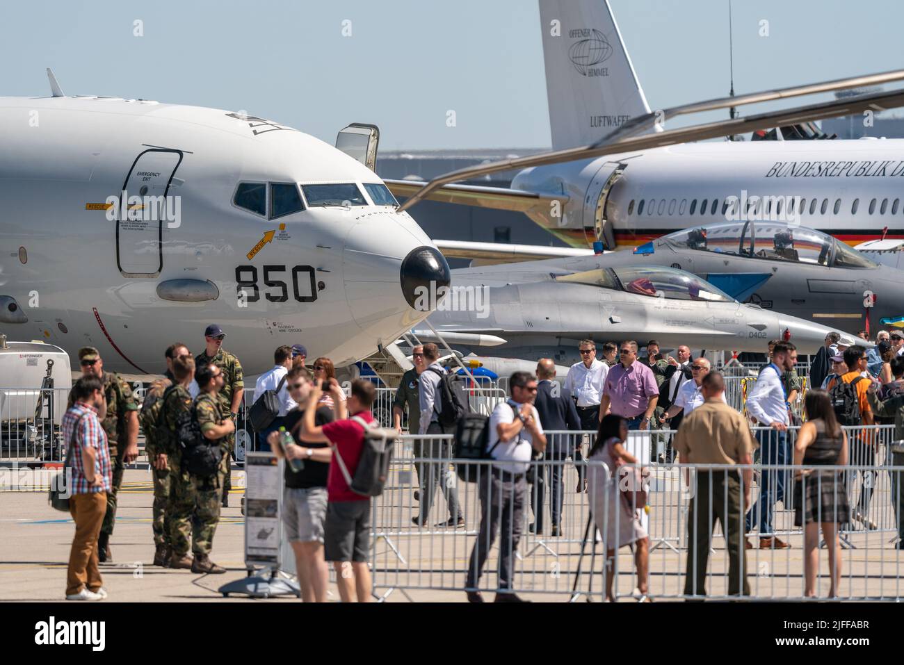 Visitors to the exhibition on the airfield against the backdrop of ...