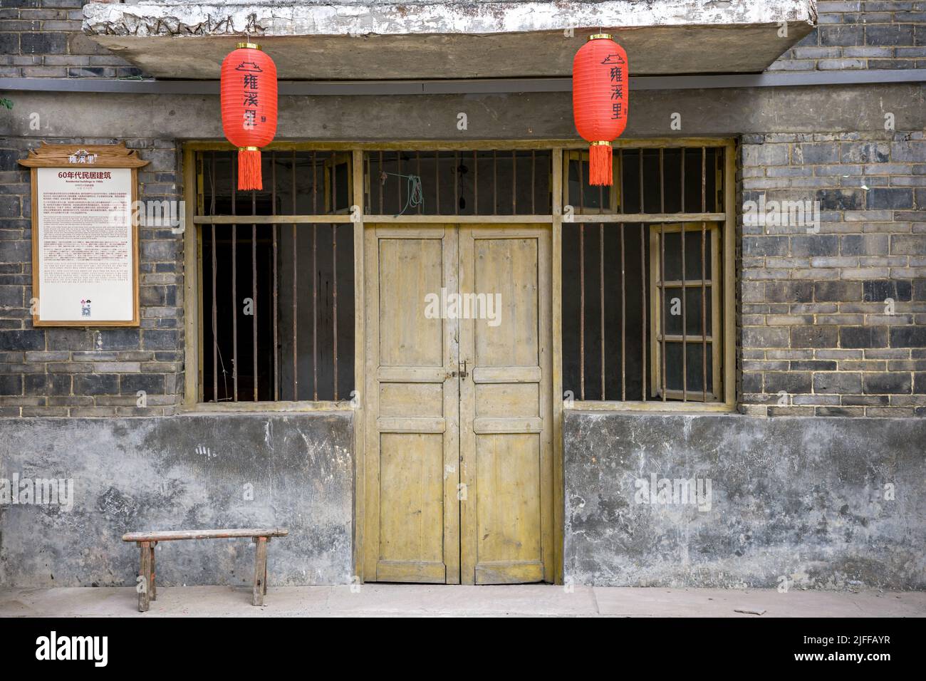 An abandoned old brick-built building in China with a brown iron door ...